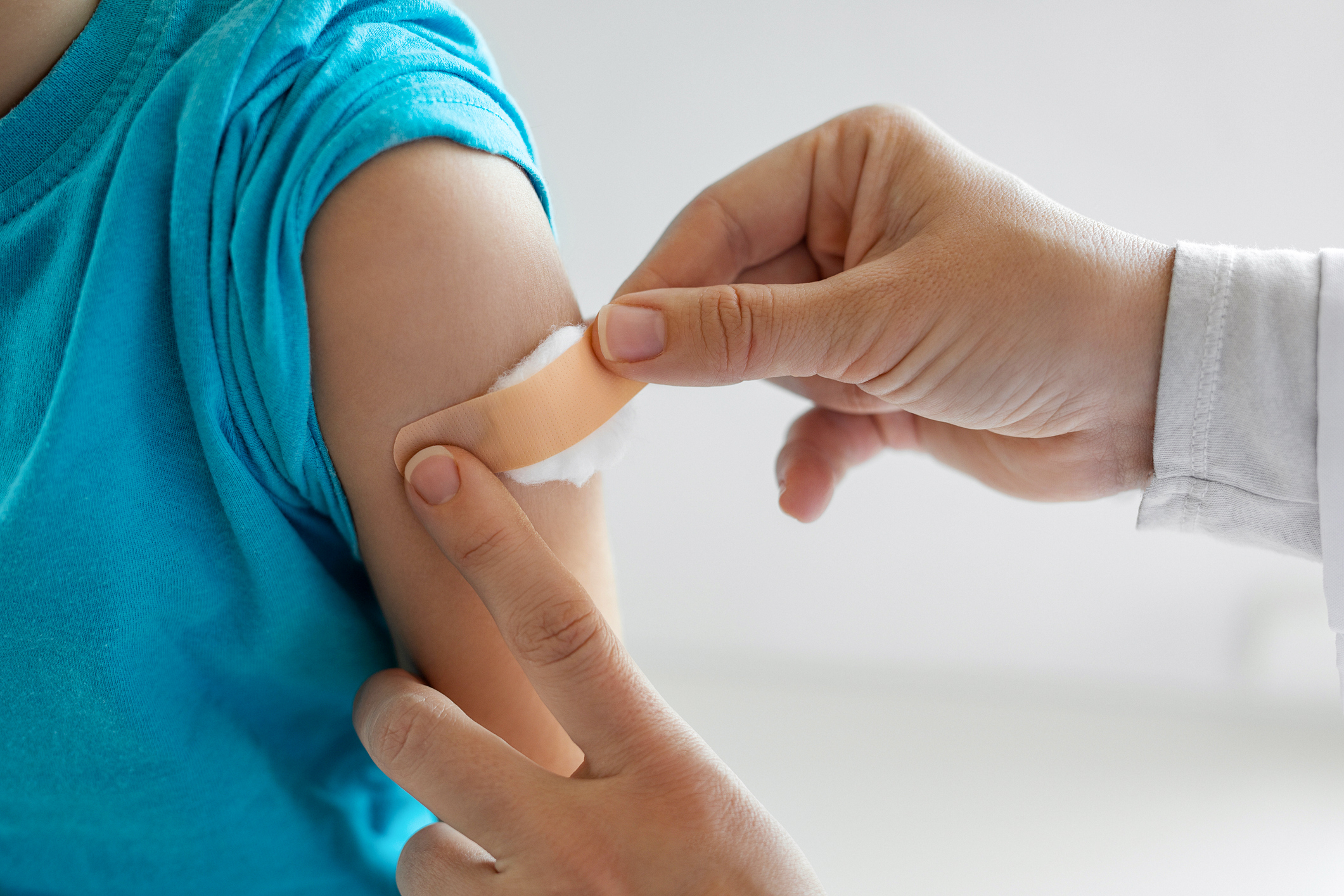 Unrecognizable doctor putting a patch on shoulder after successful ...